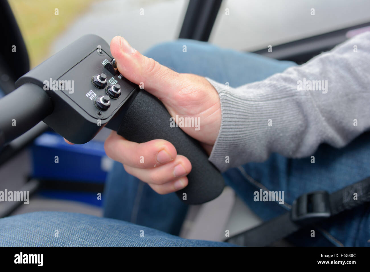 Hand on steering controls Stock Photo - Alamy