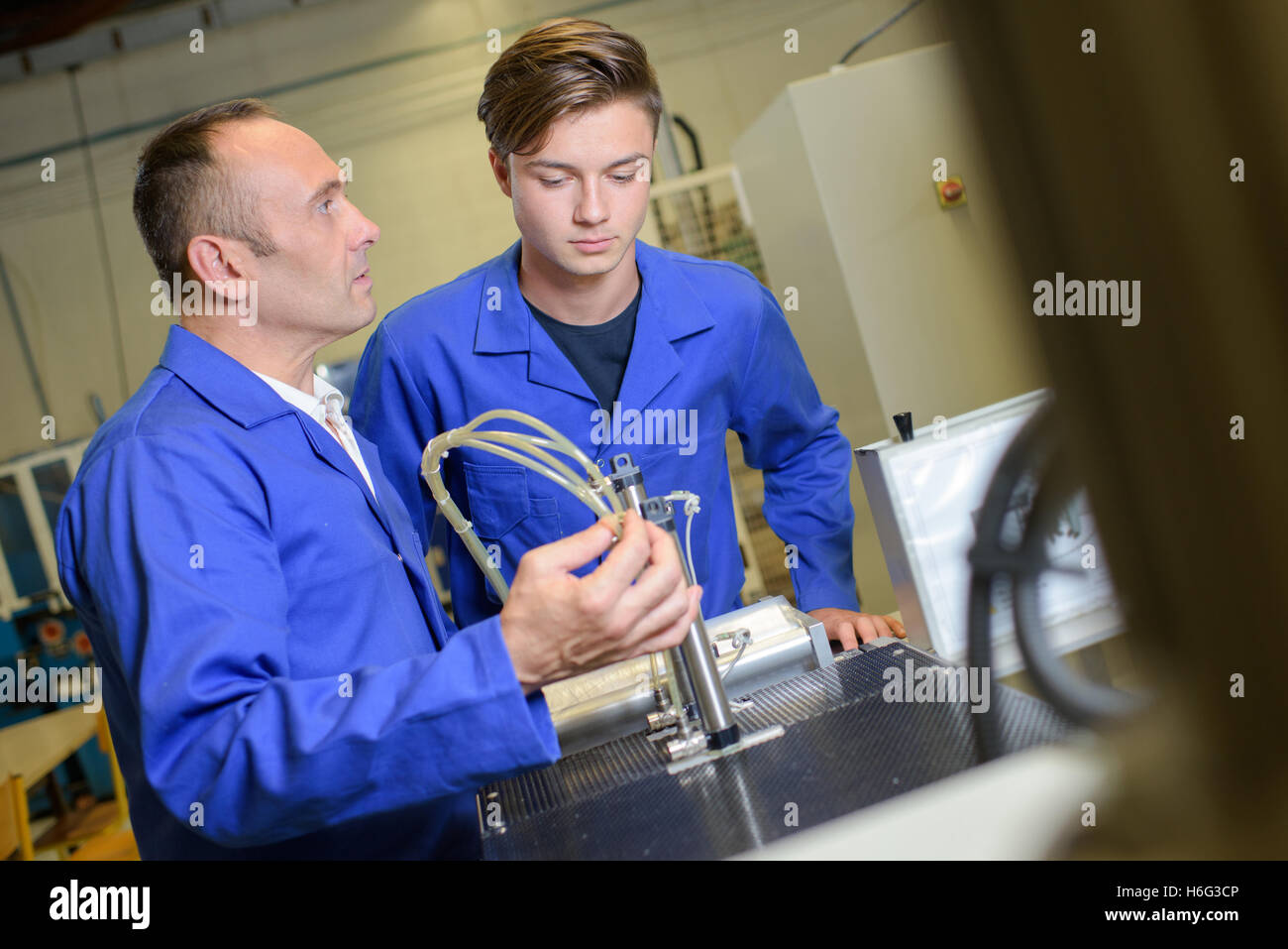 Apprentice watching teacher Stock Photo - Alamy