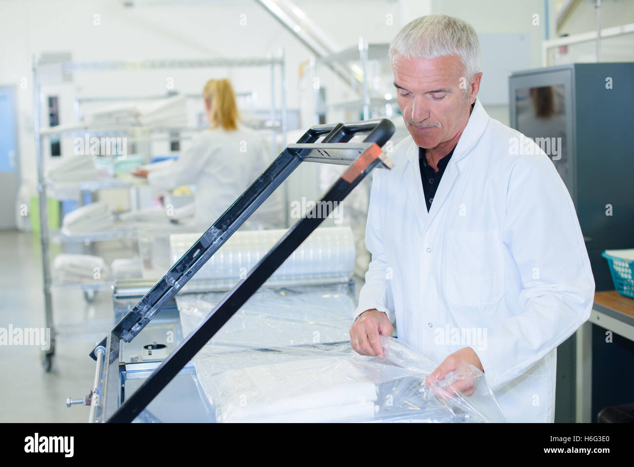 Man shrink wrapping clean laundry Stock Photo - Alamy