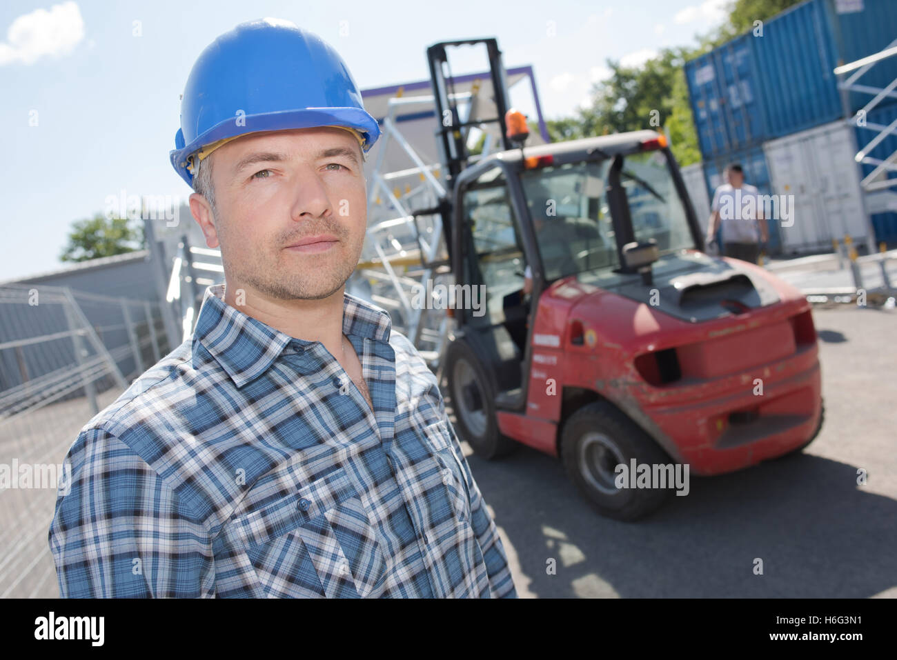 Portrait of man in front of forklift Stock Photo - Alamy