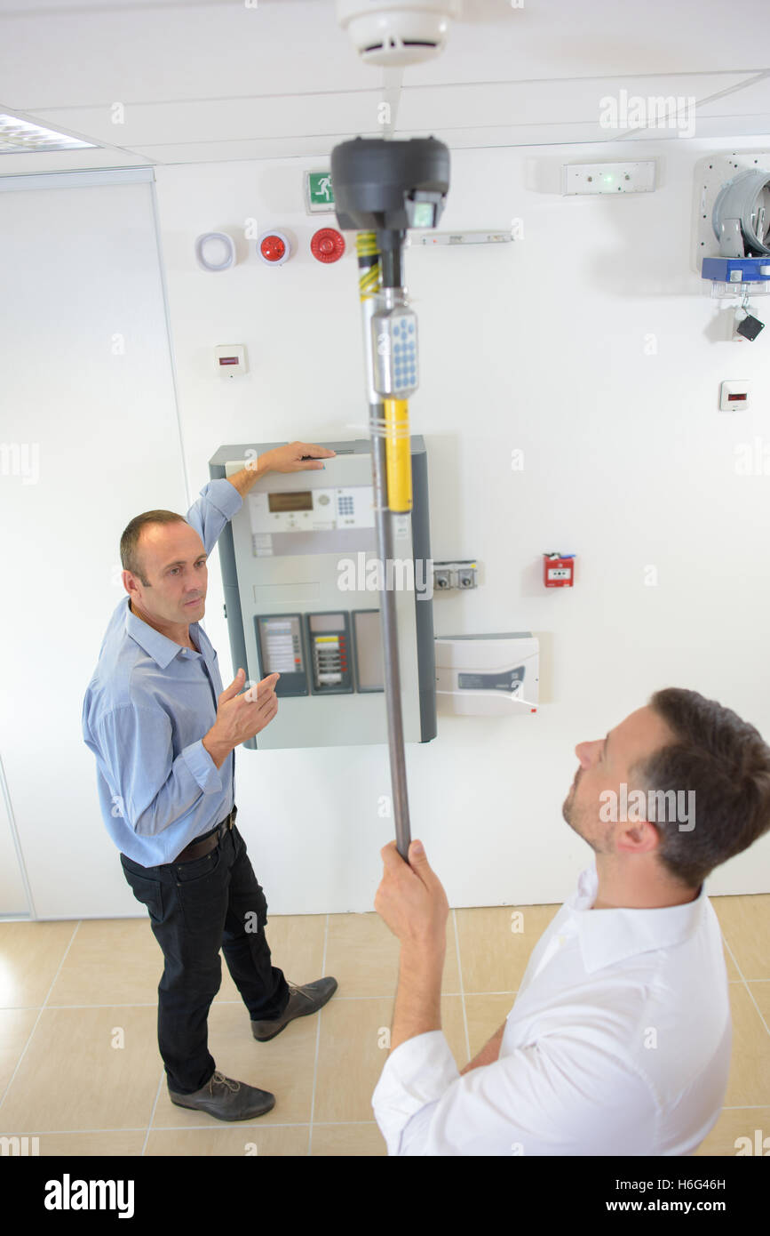 Man testing smoke detector Stock Photo - Alamy