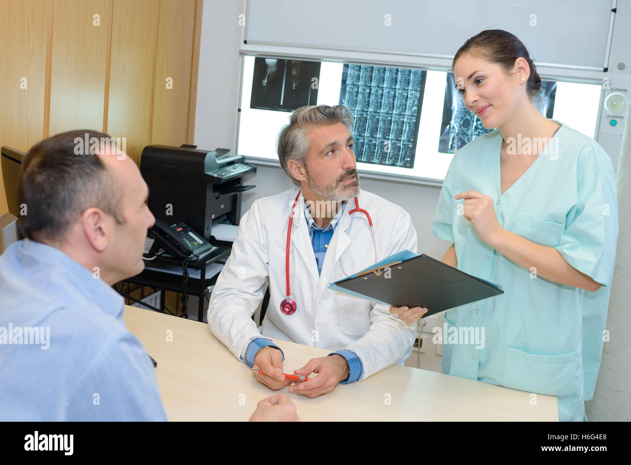 Medical staff giving results to patient Stock Photo - Alamy