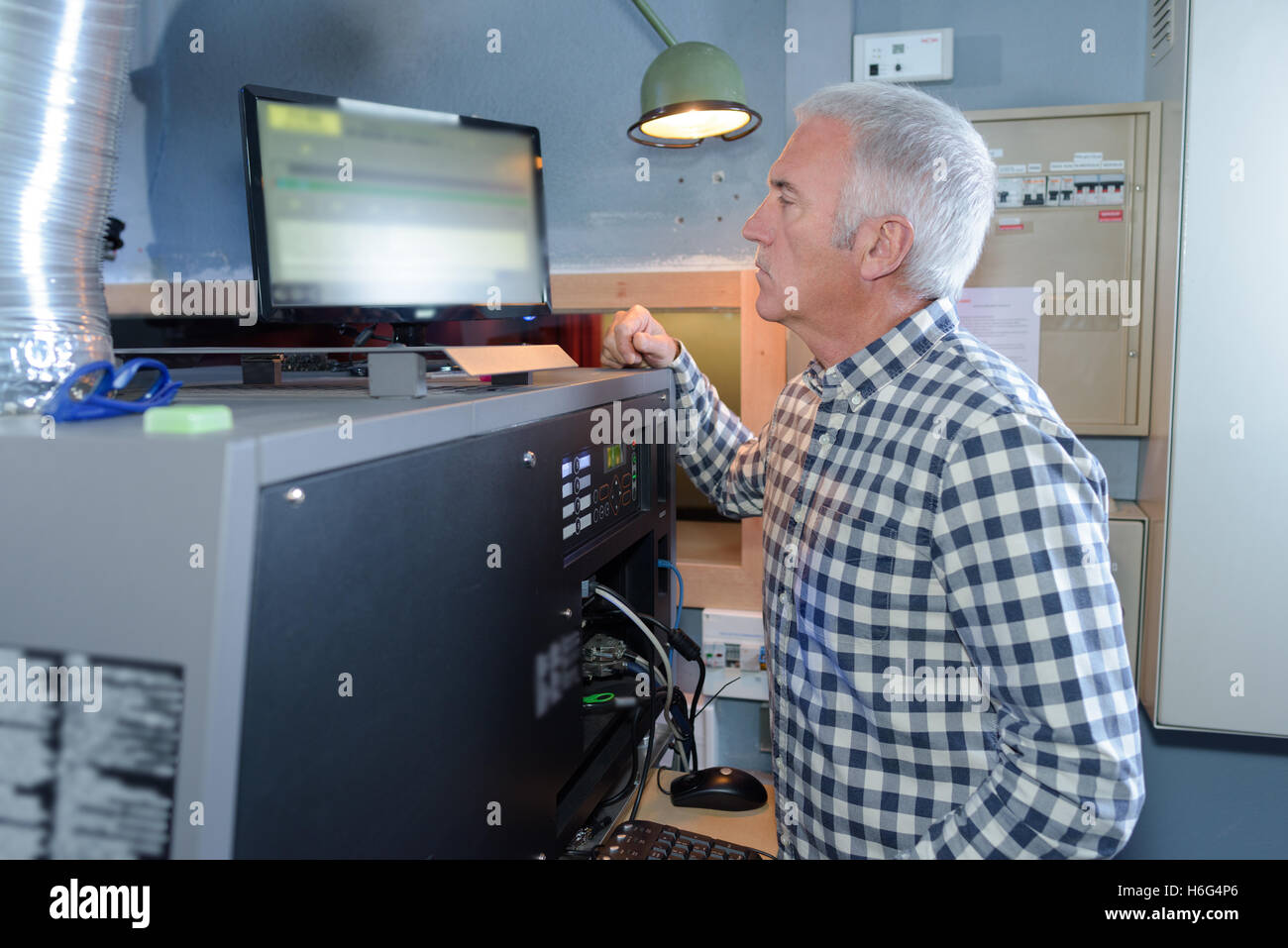 Man looking at computer screen on machine Stock Photo - Alamy