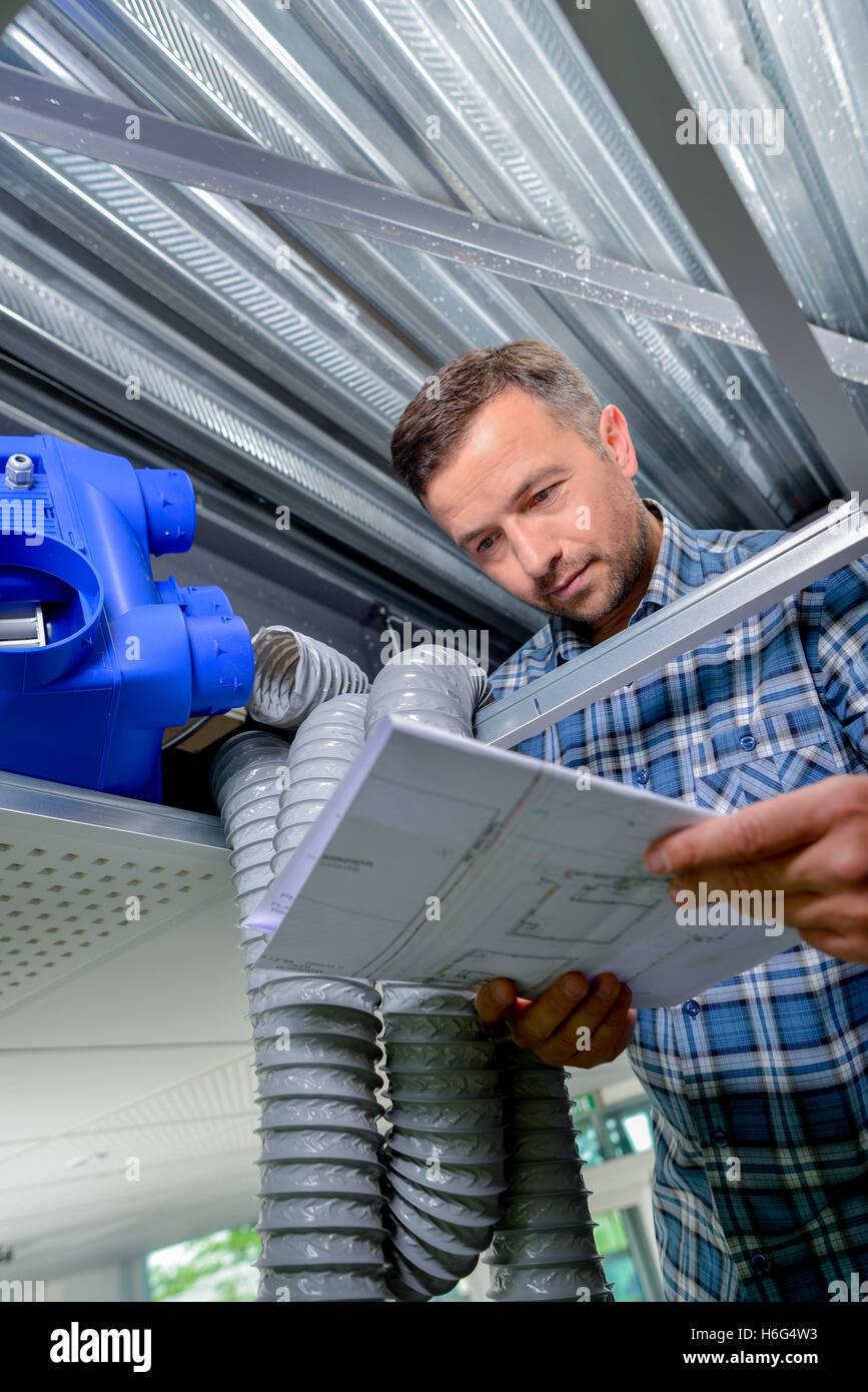 Builder looking at installation instructions Stock Photo - Alamy