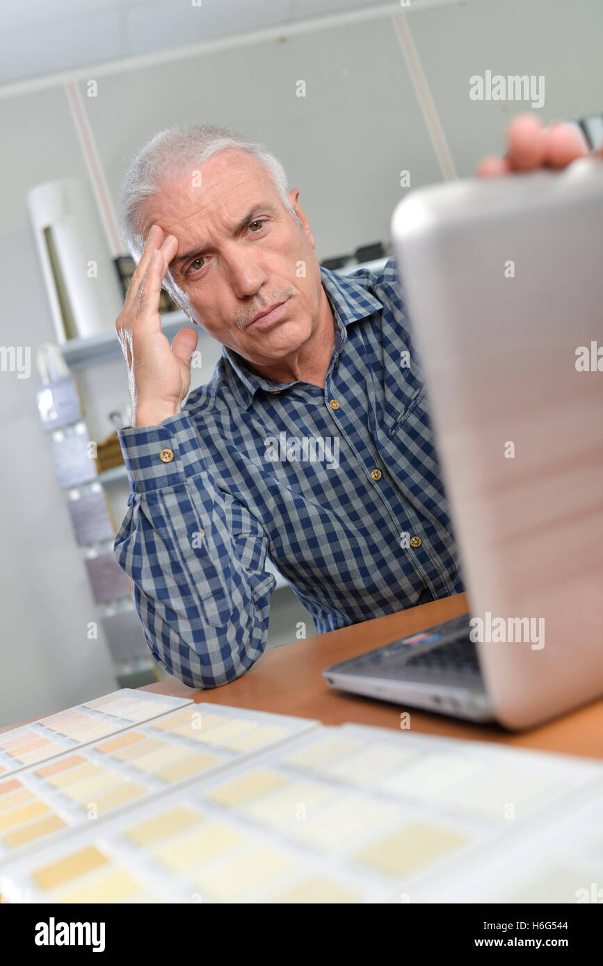 Man with laptop, looking troubled Stock Photo - Alamy