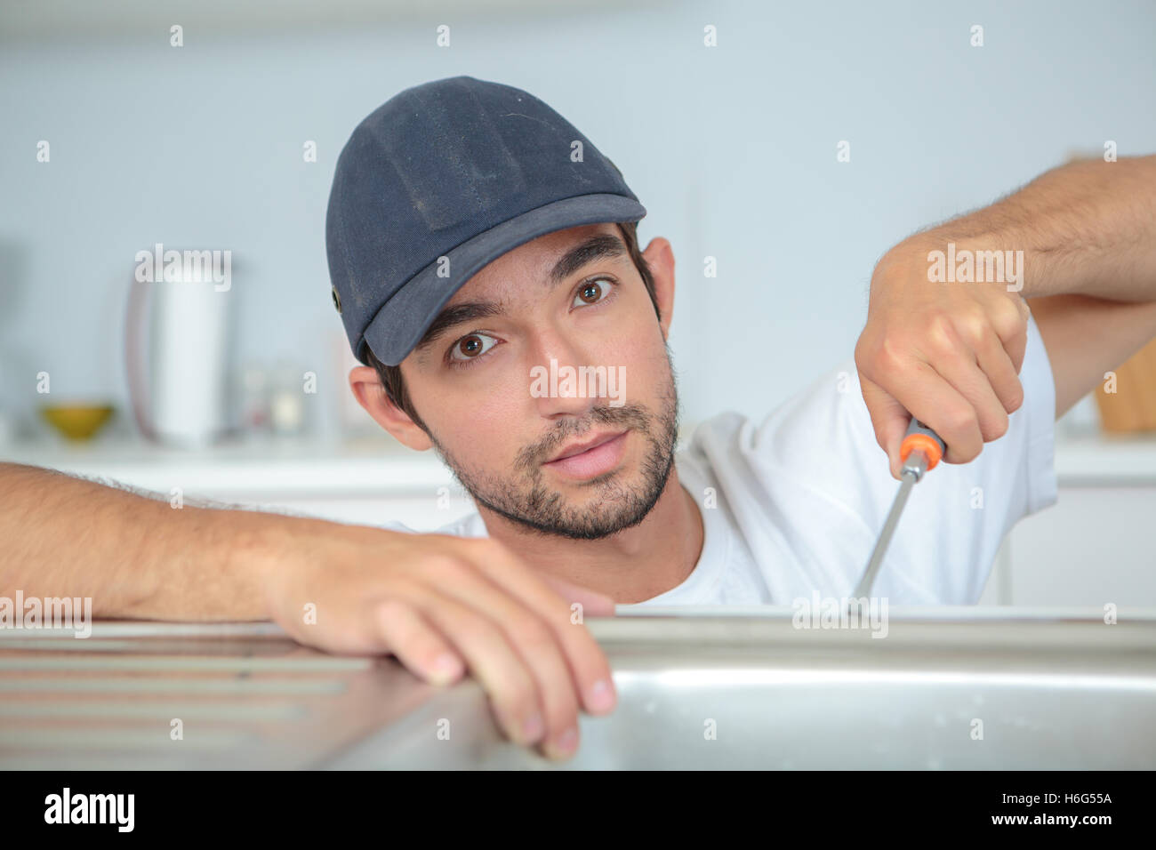 Man fitting kitchen sink Stock Photo - Alamy