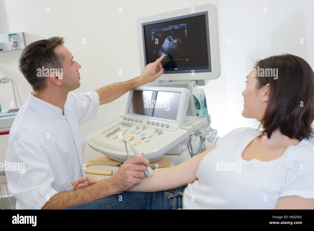 Doctor performing ultrasound explaining findings to patient Stock Photo ...