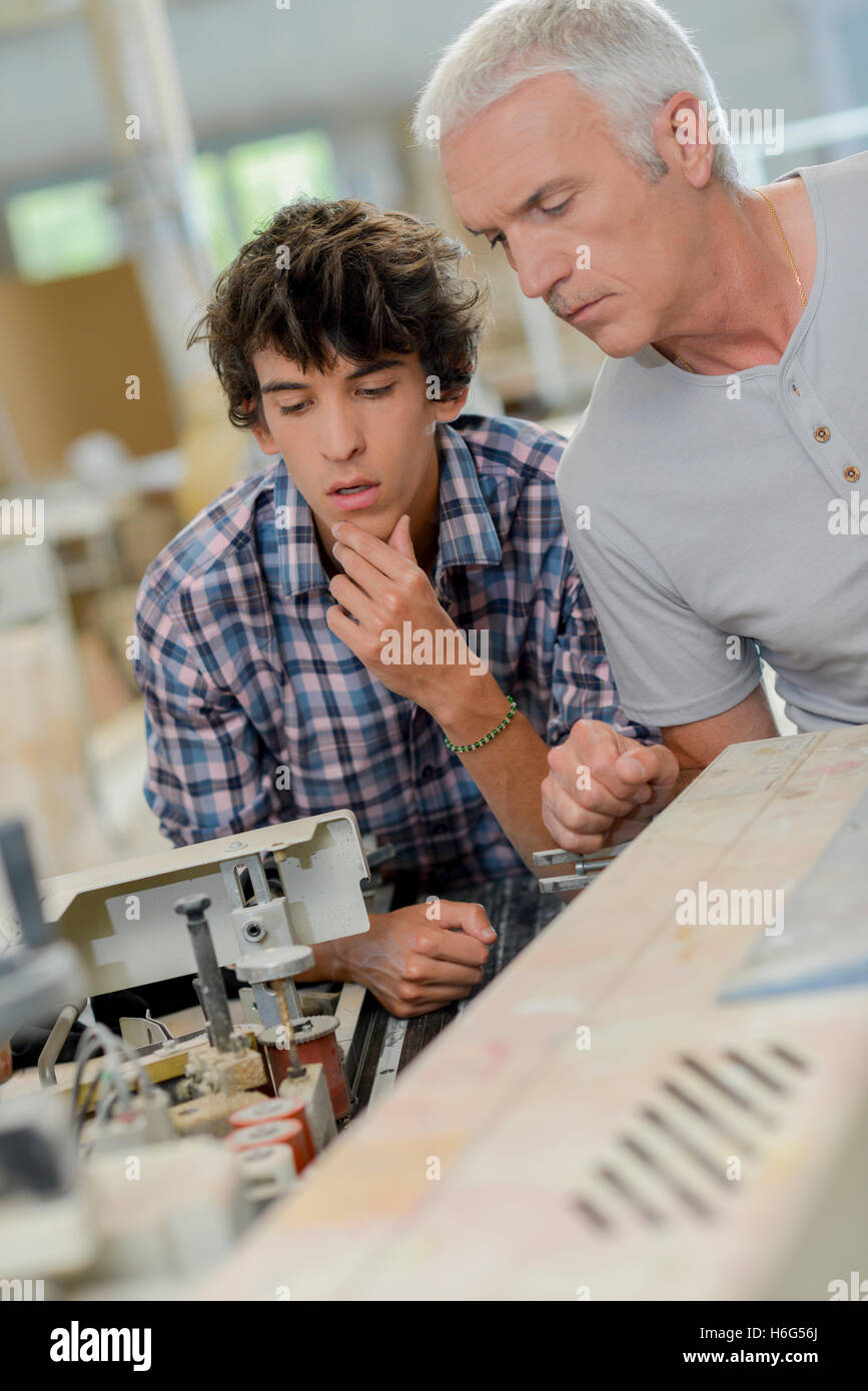 Carpenter working with apprentice Stock Photo - Alamy