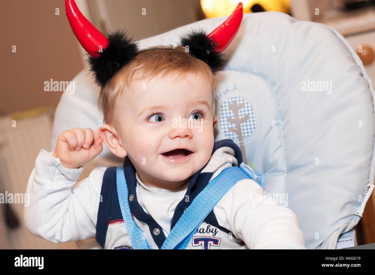 Happy smiling toddler wearing devils horns Stock Photo - Alamy