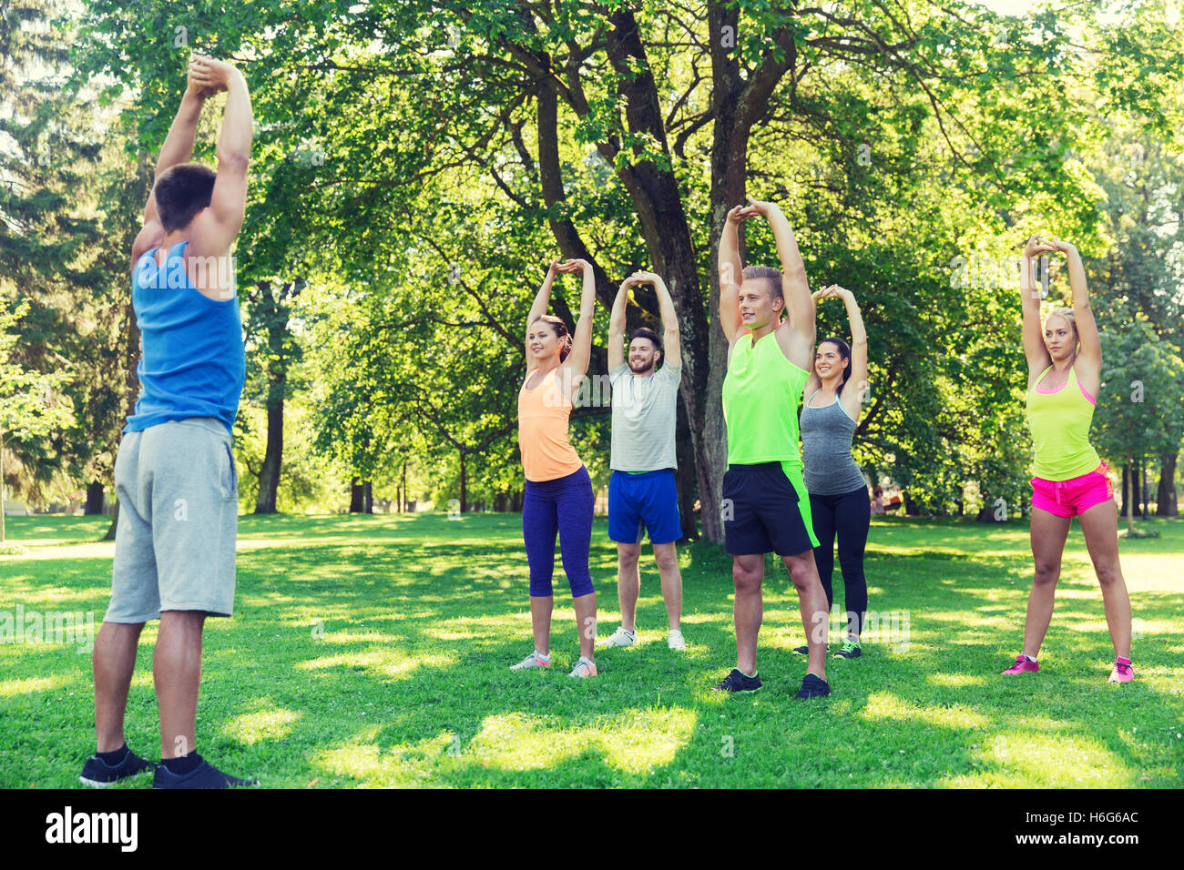 group of friends or sportsmen exercising outdoors Stock Photo - Alamy