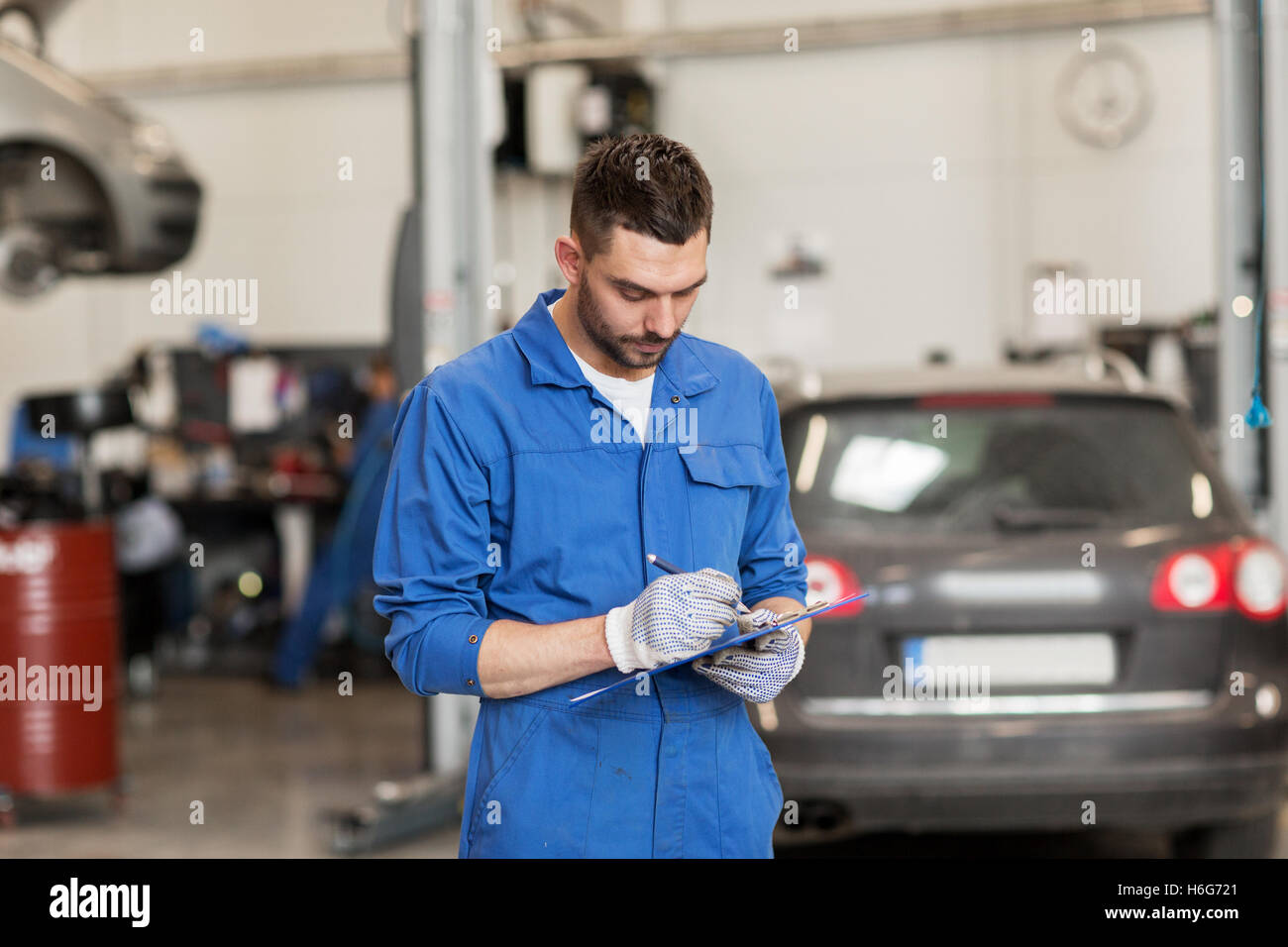auto mechanic man with clipboard at car workshop Stock Photo - Alamy