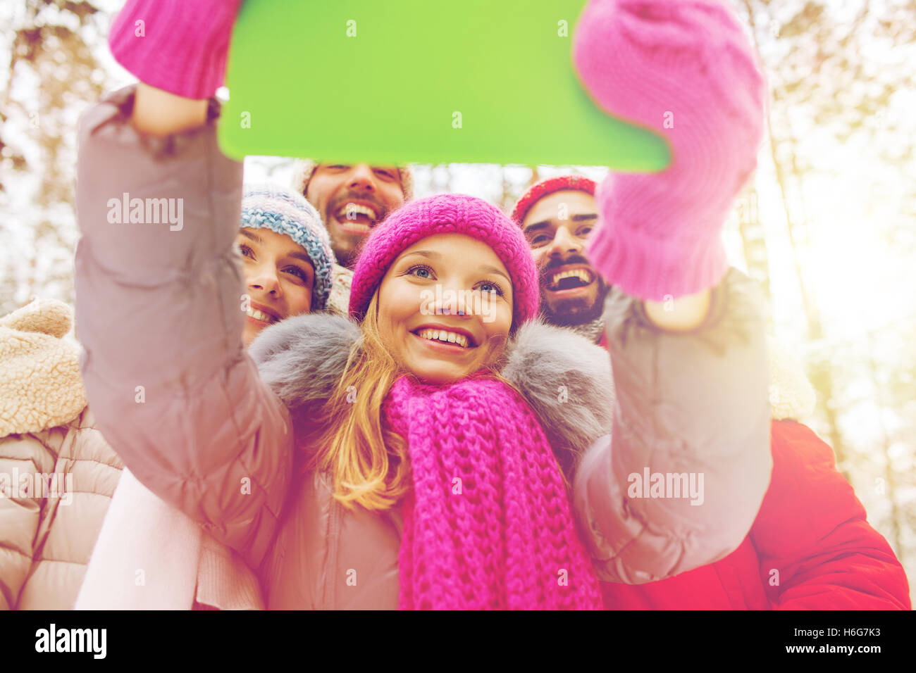 smiling friends with tablet pc in winter forest Stock Photo - Alamy