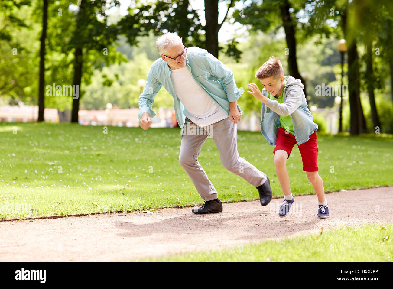 grandfather and grandson racing at summer park Stock Photo - Alamy