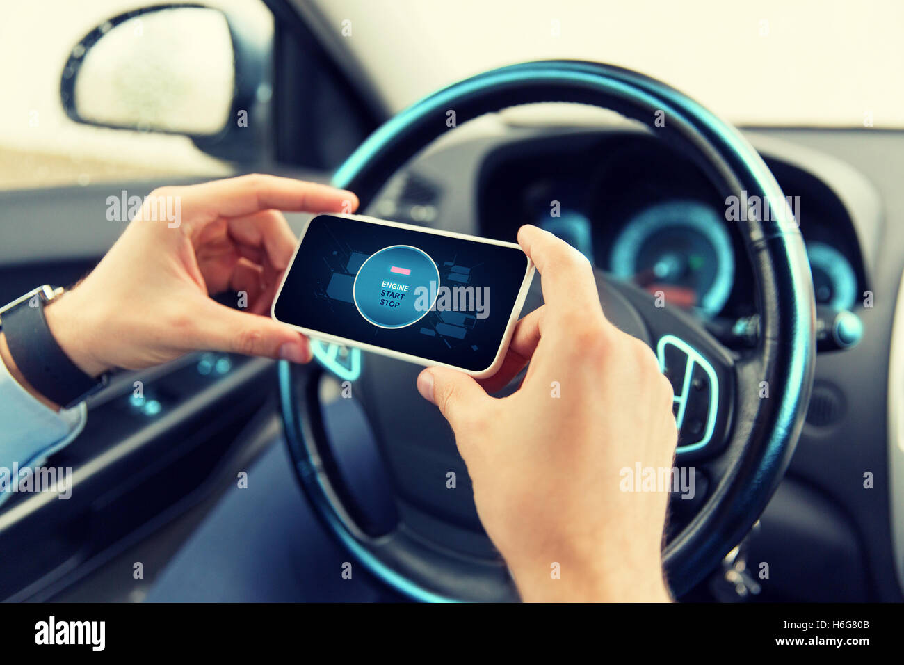 hands with start engine icon on smartphone in car Stock Photo - Alamy