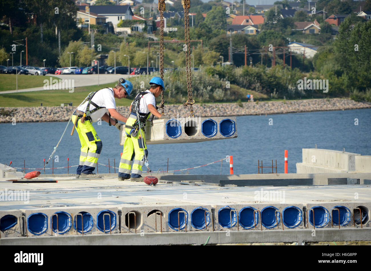 Construction workers handle concrete elements delivered by crane Stock ...