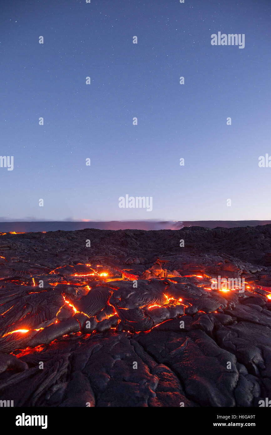 stars fill the pre-dawn sky as hot lava glows through the cracks of ...