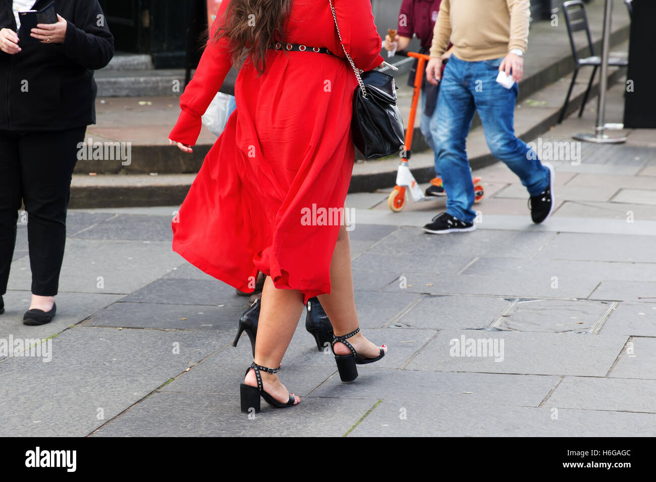 woman with a red dress walking in the city Stock Photo - Alamy