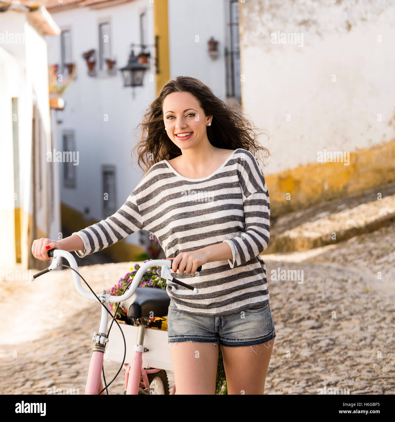 Happy beautiful female tourist riding a bicycle Stock Photo - Alamy