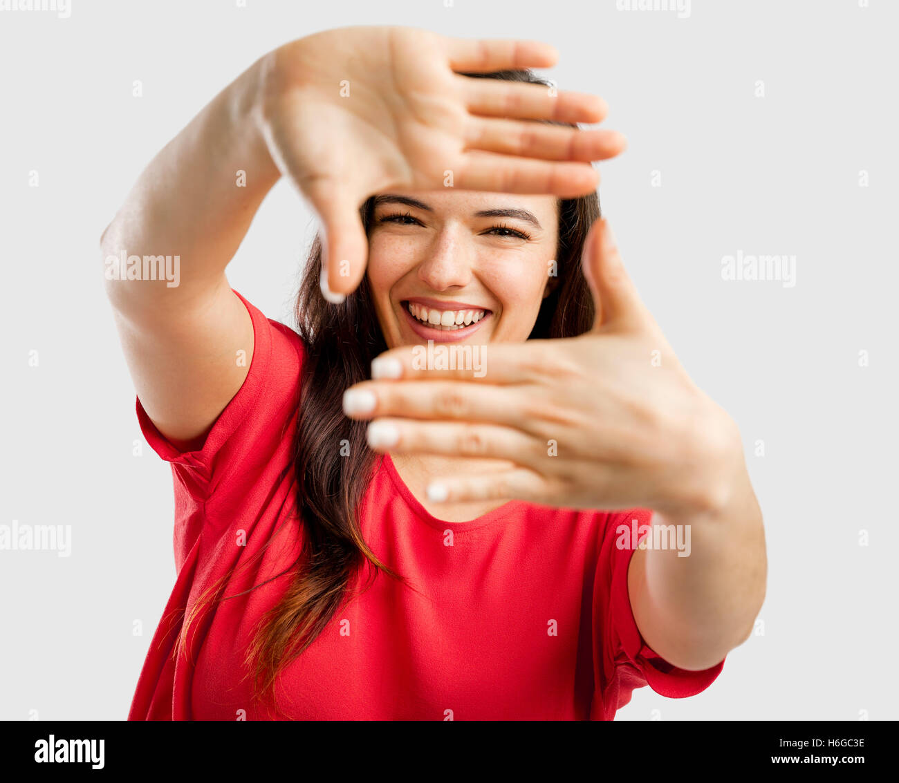 Portrait of a lovely woman framing her face with her hands and smiling ...