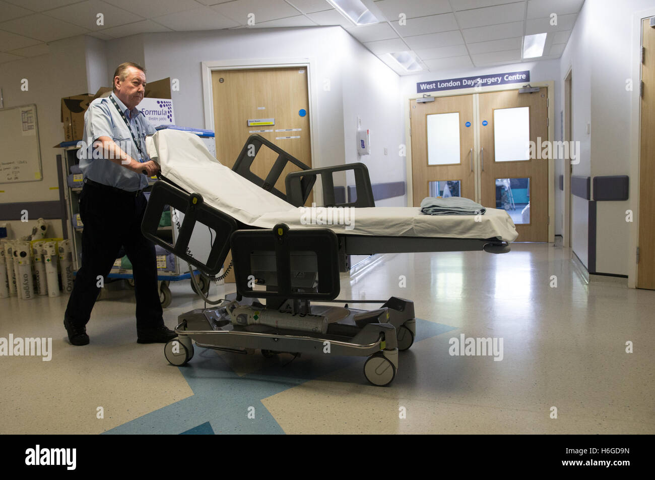 A hospital porter wheels an empty trolley through a corridor to collect ...