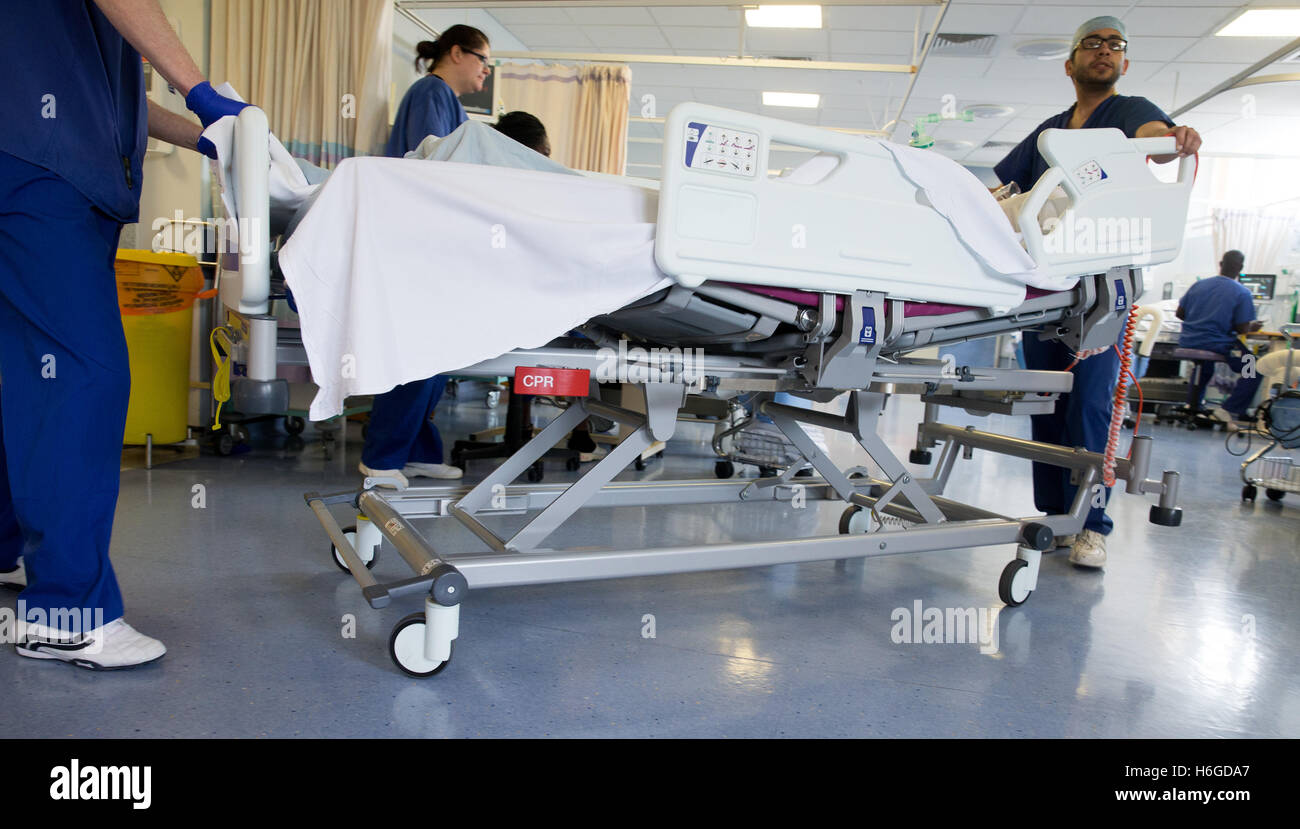 A hospital worker wheels a patient on a trolley through a ward after an ...