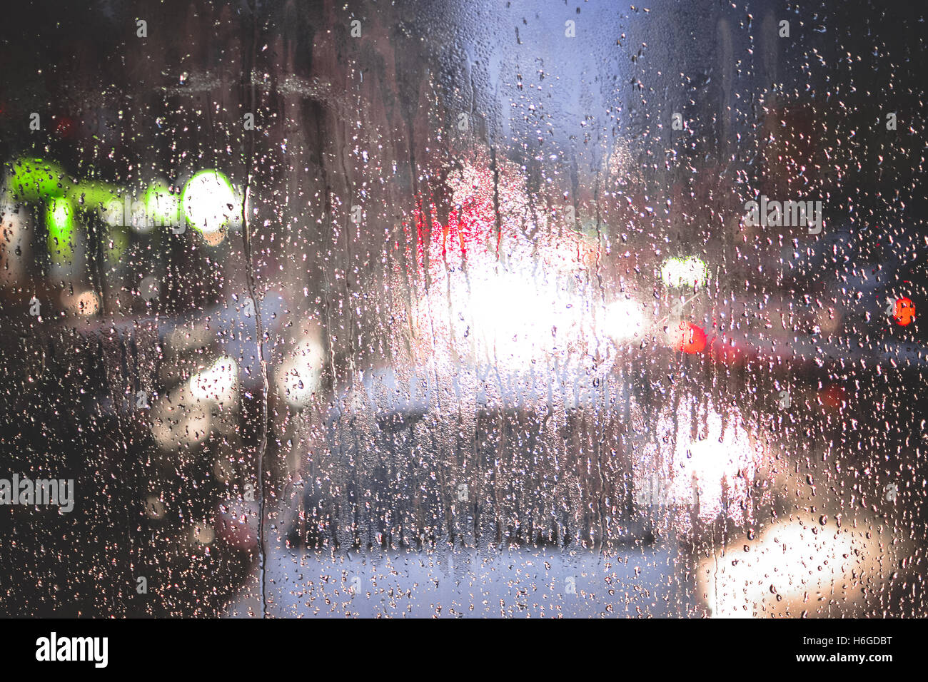 Rain drops on window and blurred traffic lights in the evening ...