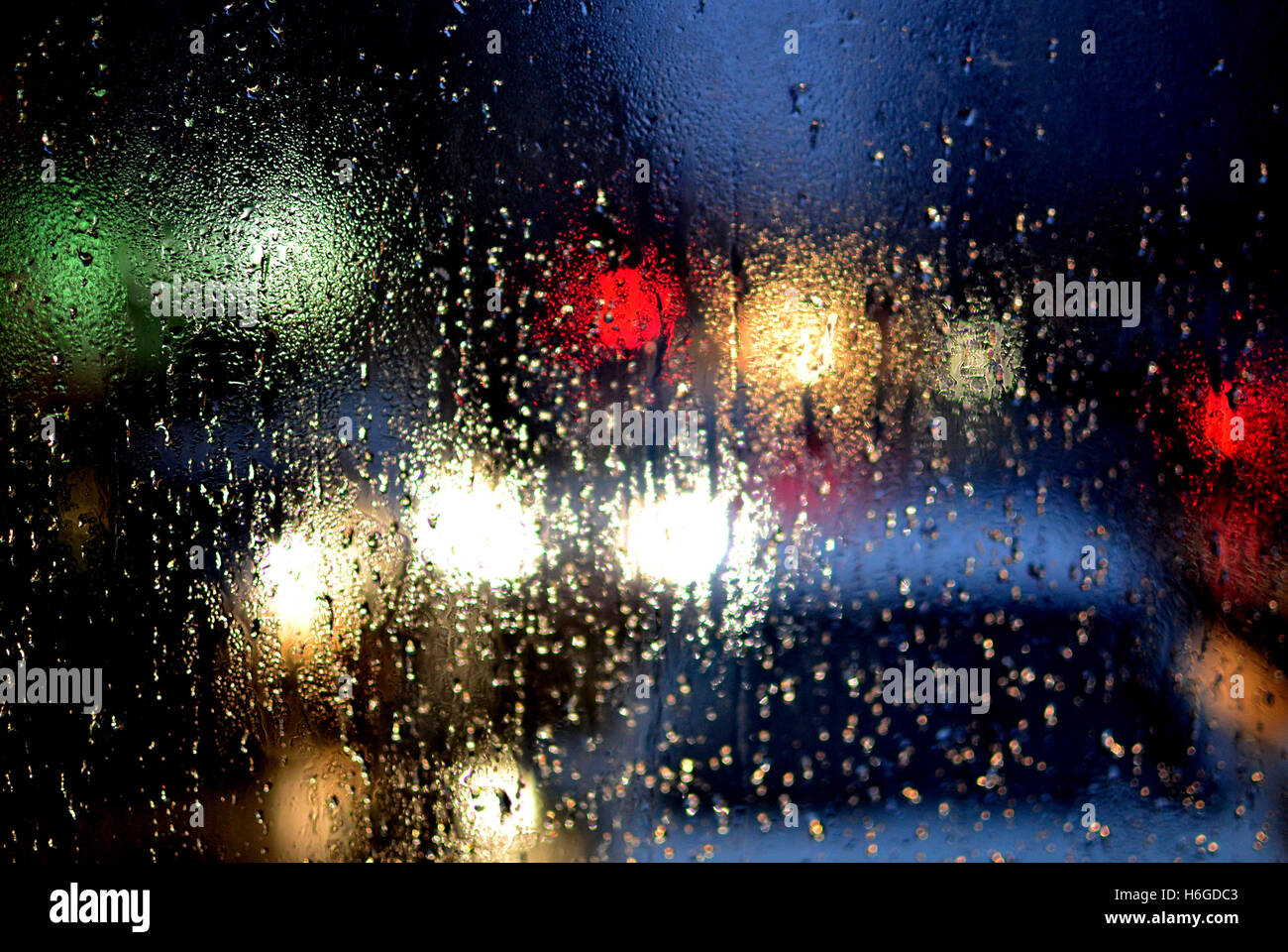 Rain drops on window and blurred traffic lights in the evening ...