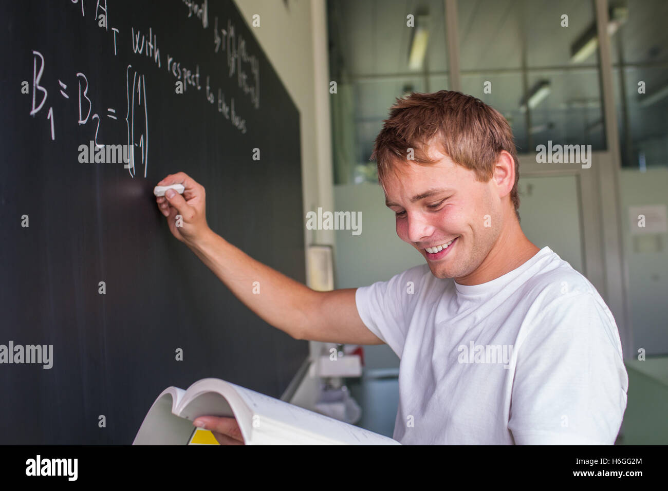 Handsome college student solving a math problem during math class in ...
