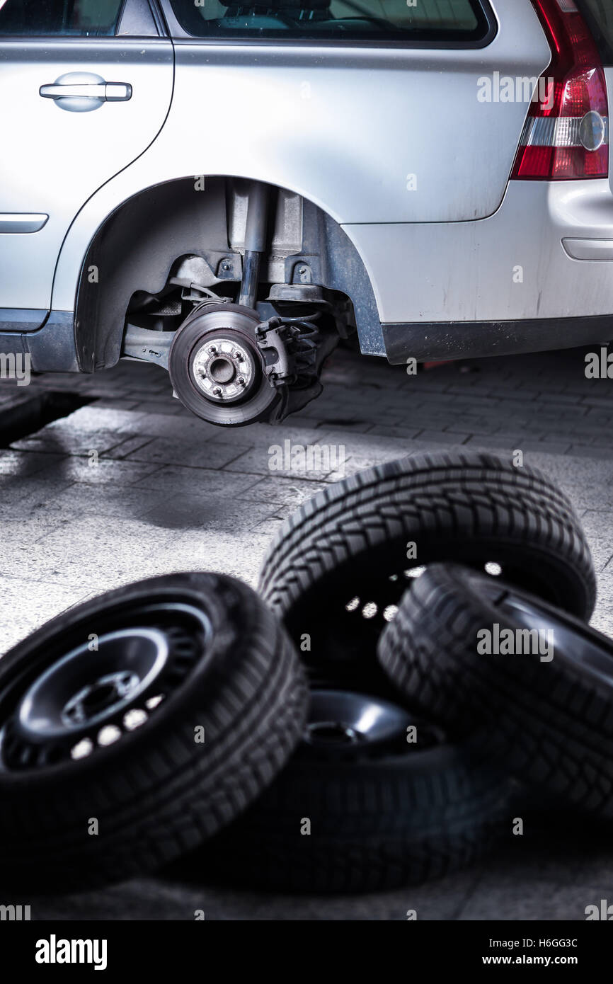 mechanic changing a wheel of a modern car (shallow DOF; color toned ...