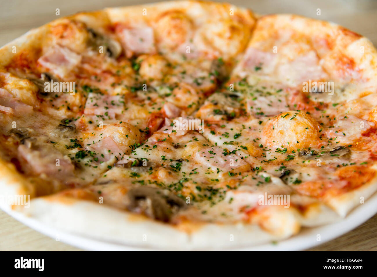 Pizza with mushrooms and ham on plate Stock Photo - Alamy