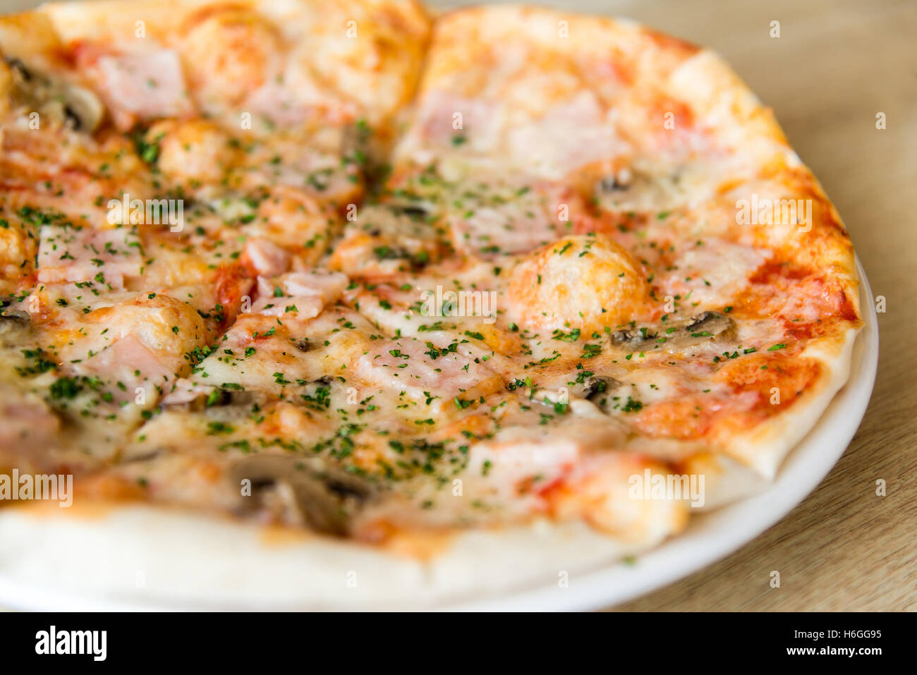 Pizza with mushrooms and ham on plate Stock Photo - Alamy