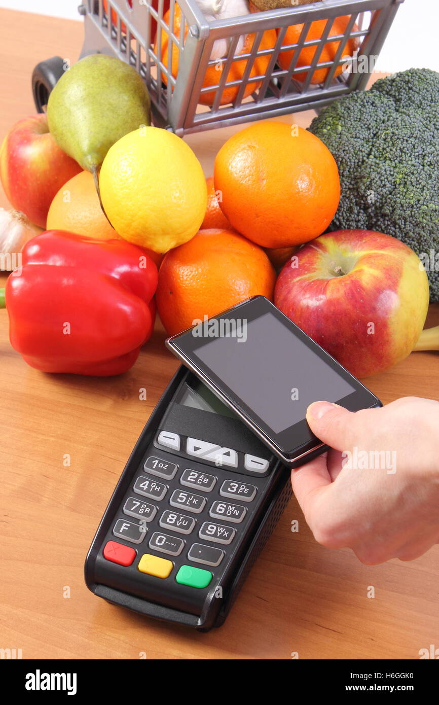 Hand using payment terminal, credit card reader with mobile phone with ...