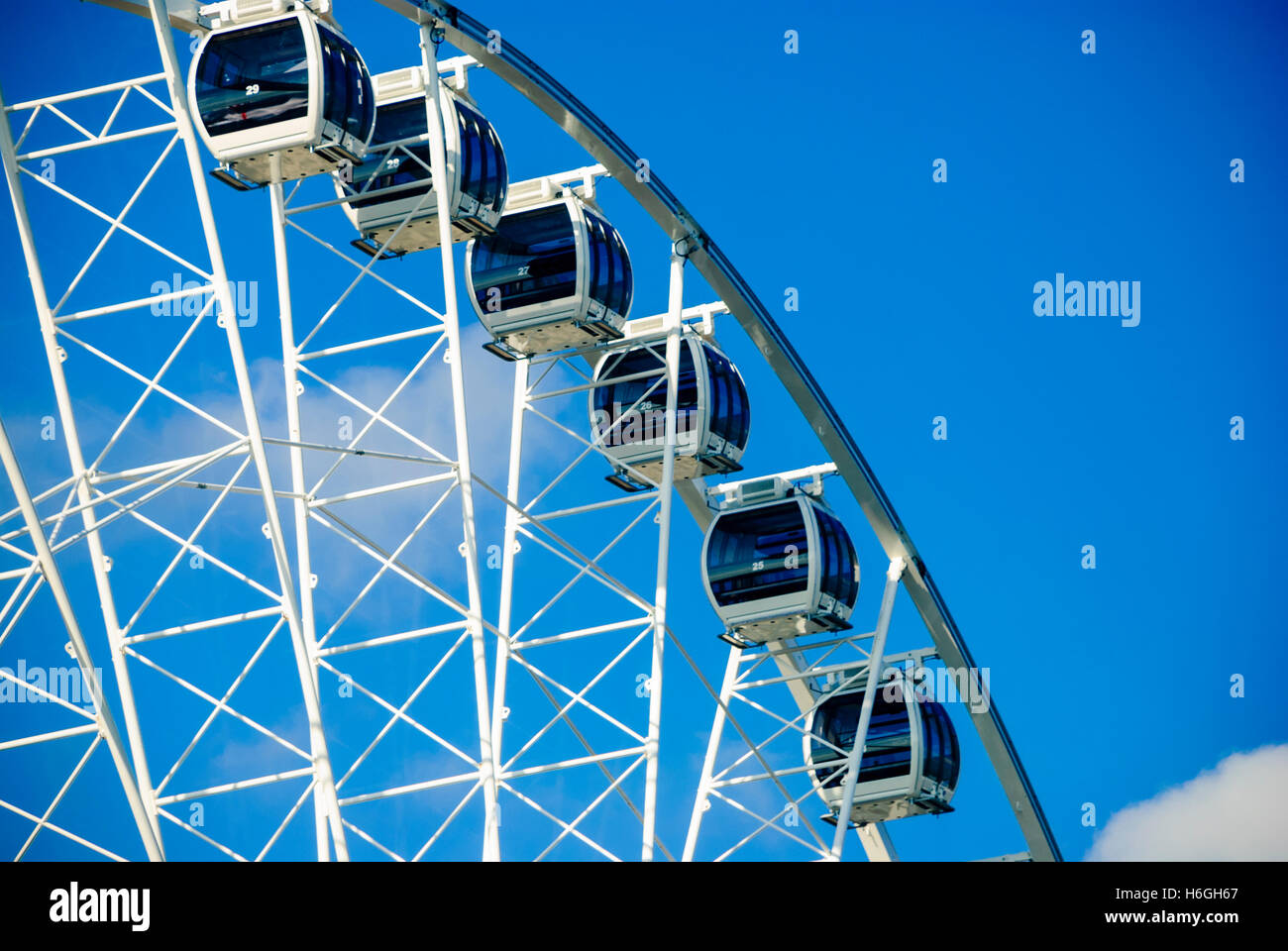 Cars on a large ferris wheel against a blue sky Stock Photo - Alamy
