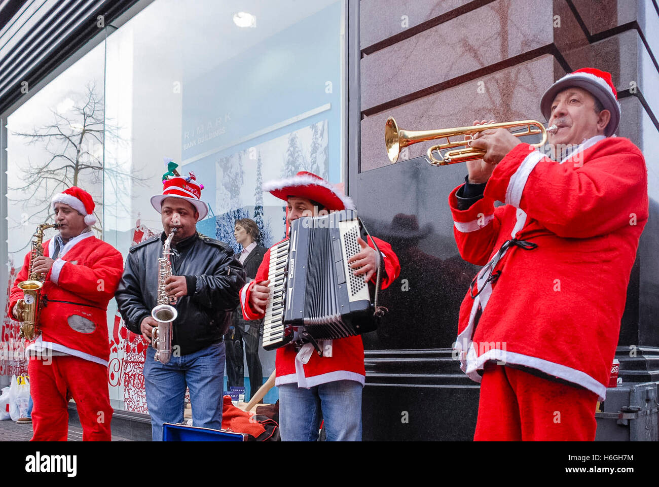 Romanian men dressed in Santa suits play musical instruments while ...