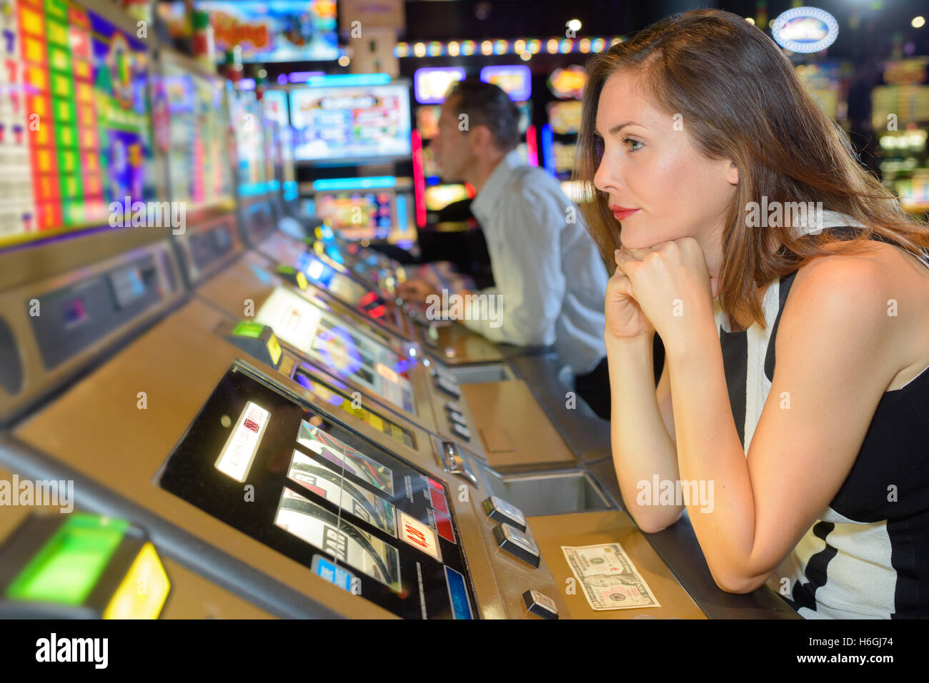 Miserable woman sat at arcade game Stock Photo - Alamy