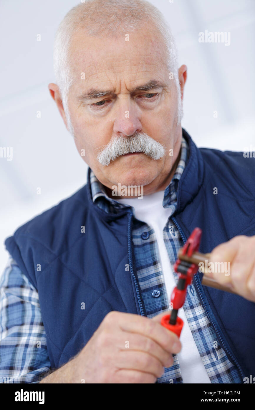 senior handyman trying to fix something Stock Photo - Alamy
