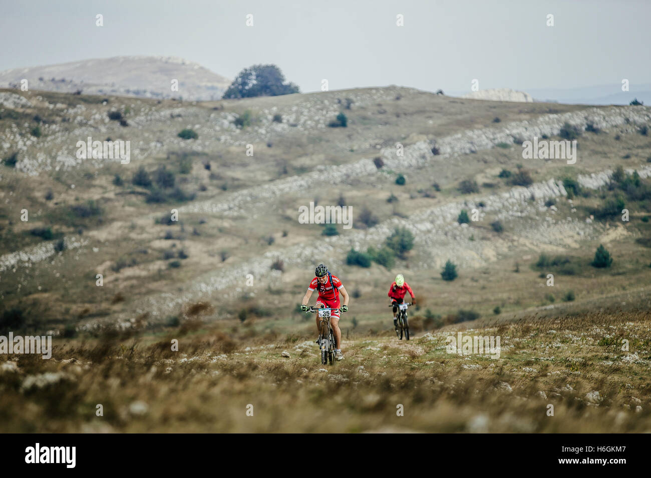 two riders rider mountain bike rides on a mountain trail during Crimean ...