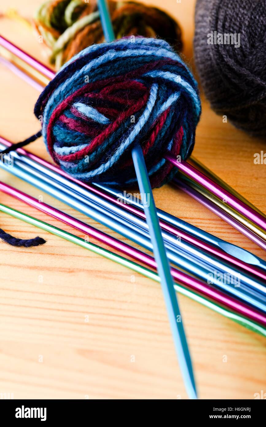 Vertical photo with ball of multi color wool with knitting needles ...
