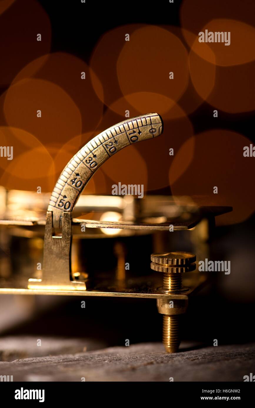 Vertical photo of old small brass sun clocks placed on worn wooden ...