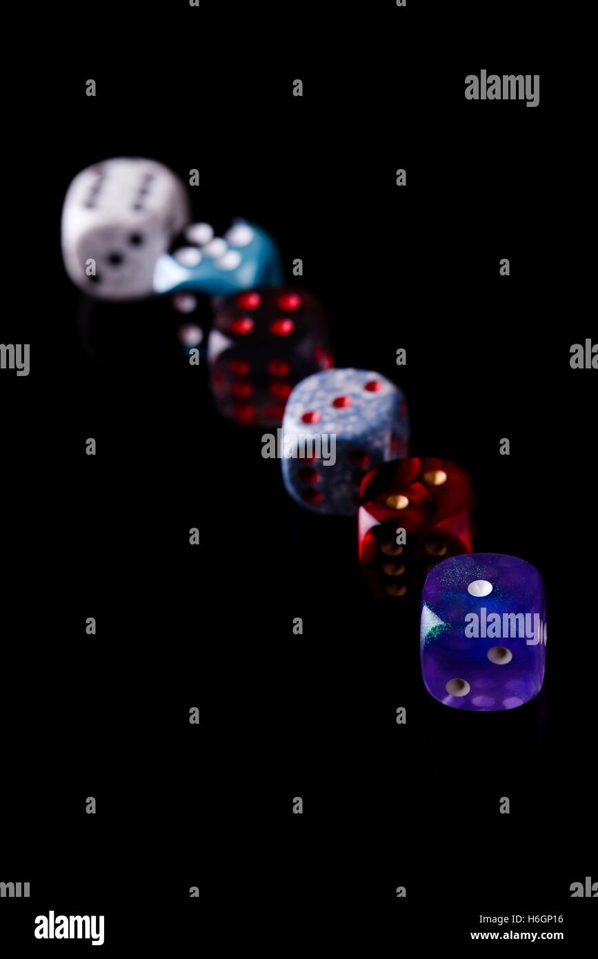 Vertical photo of colorful dices which are placed on black board. Each ...