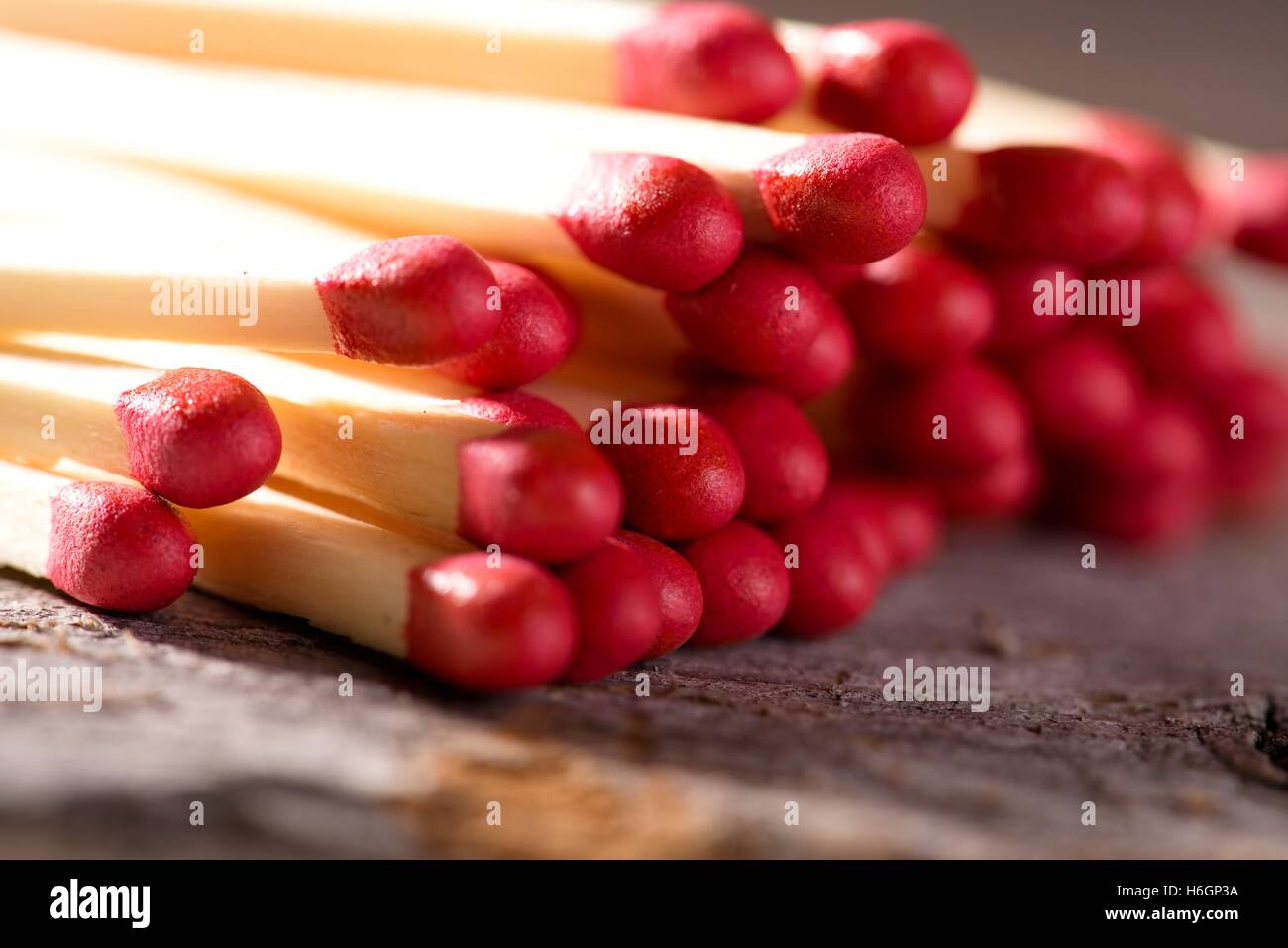 Horizontal photo with several long wooden matchsticks with red heads ...