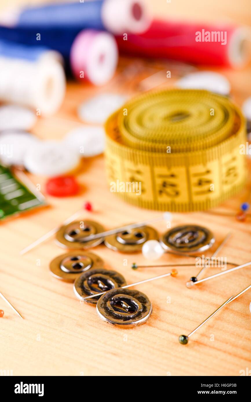 Vertical photo with several sewing accessories as buttons, measuring ...