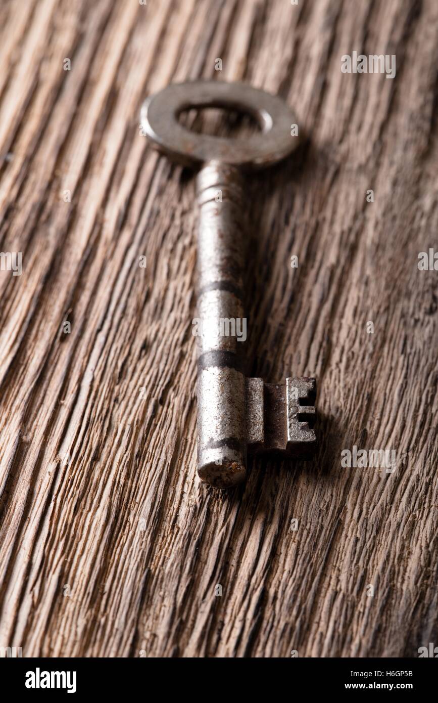 Vertical photo. Old silver key. Old key placed on wooden board. Wooden ...