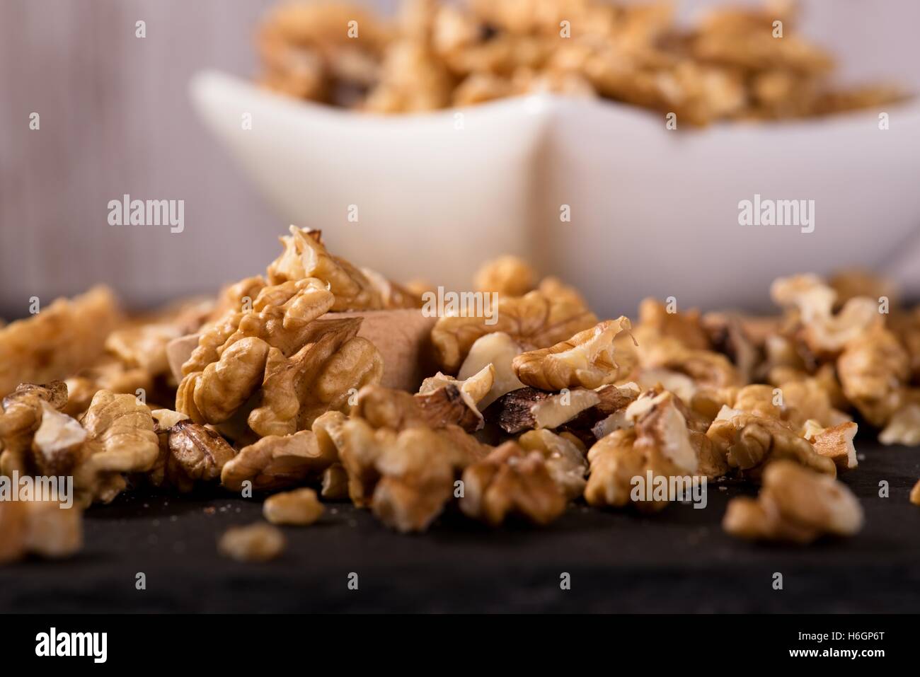 Horizontal photo of several walnuts which are spilled on black slate ...