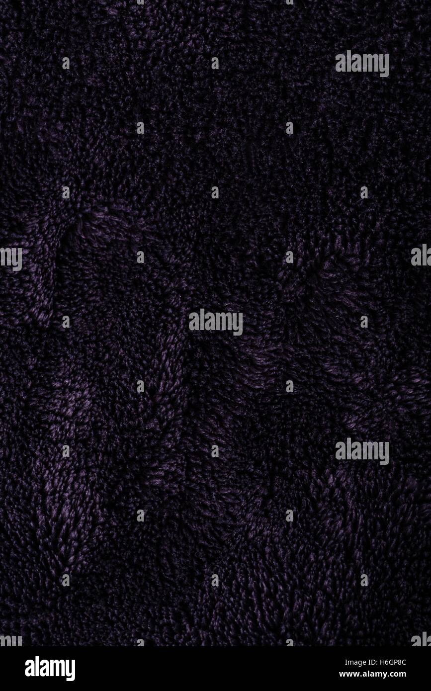 Vertical texture photo of dark black blanket. The surface is little bit ...