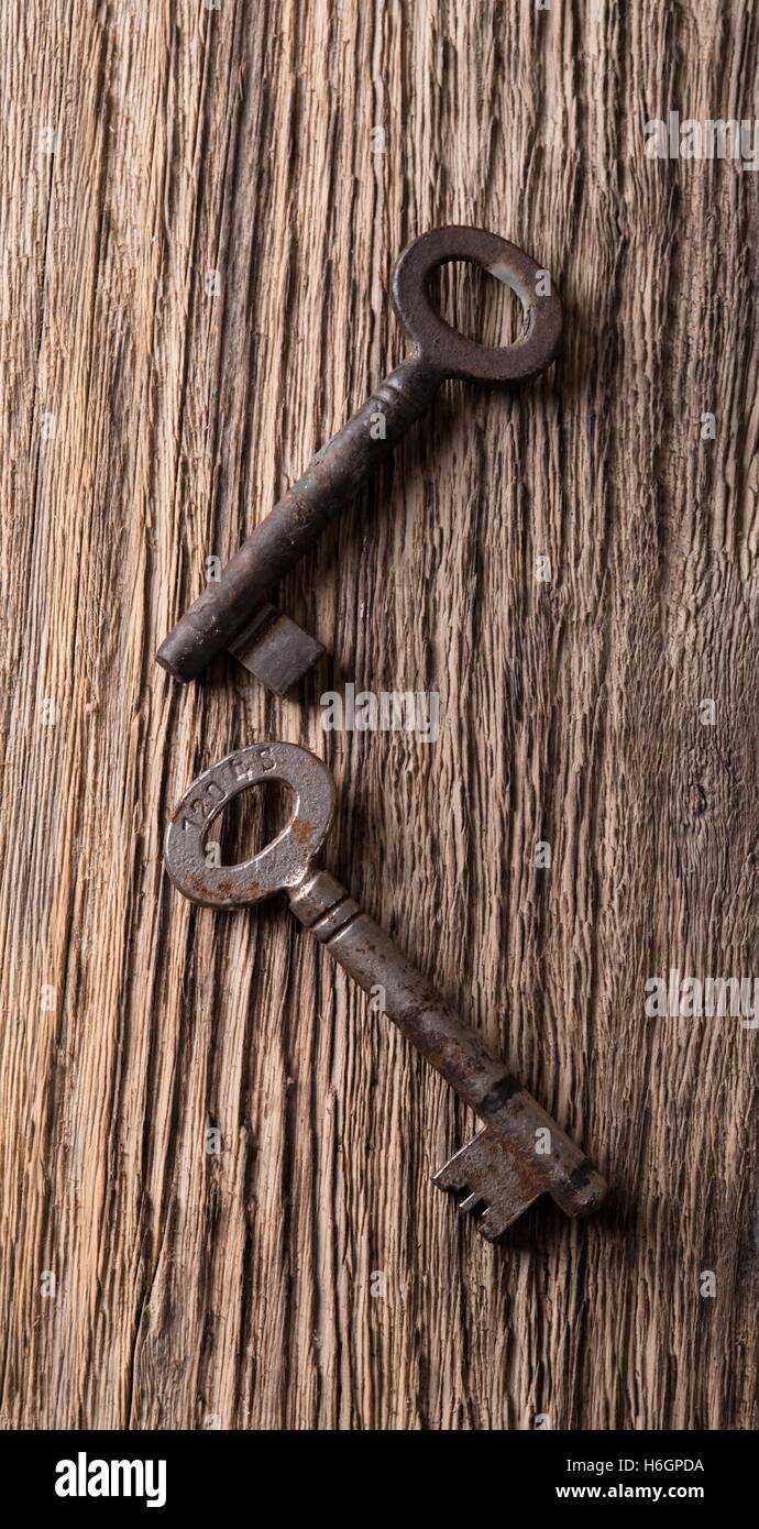 Vertical photo. Two old keys. Old keys placed on wooden board. Wooden ...