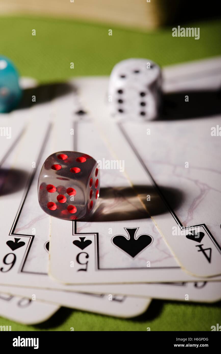 Vertical photo of used playing cards with flush. Few dices are placed ...