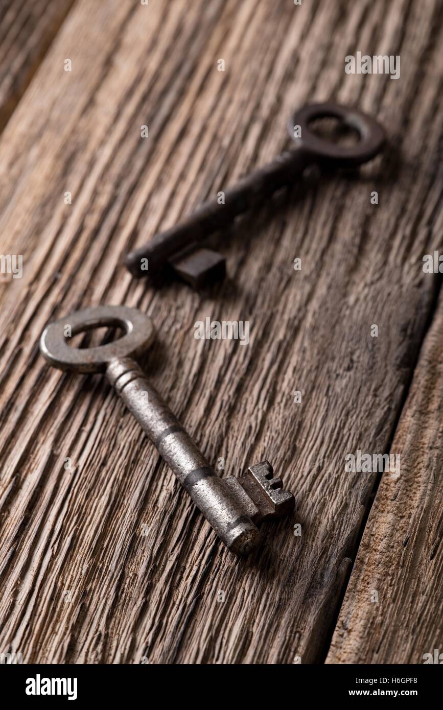 Vertical photo. Two old keys. Old keys placed on wooden board. Wooden ...