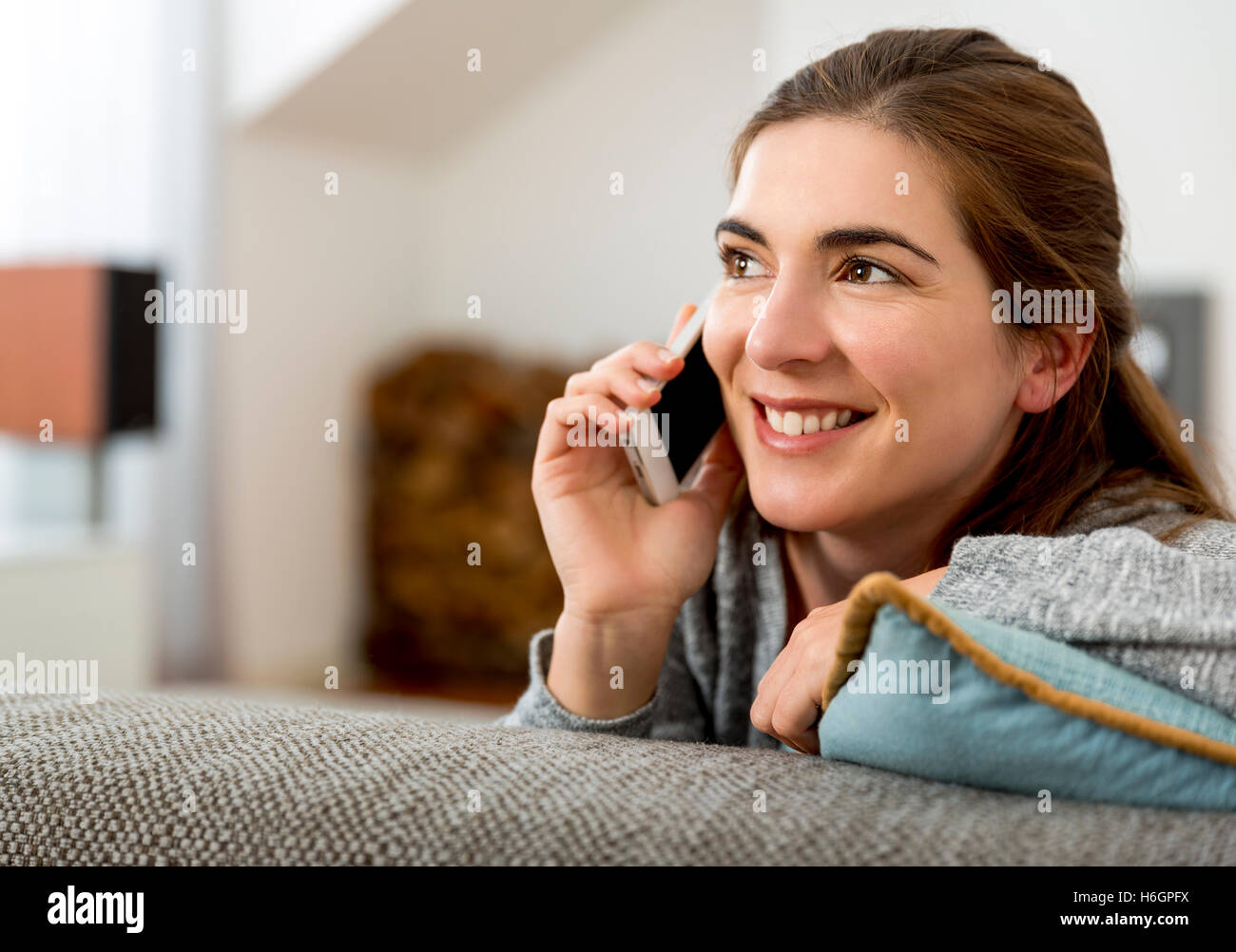 Happy beautiful woman at home sending text messages Stock Photo - Alamy