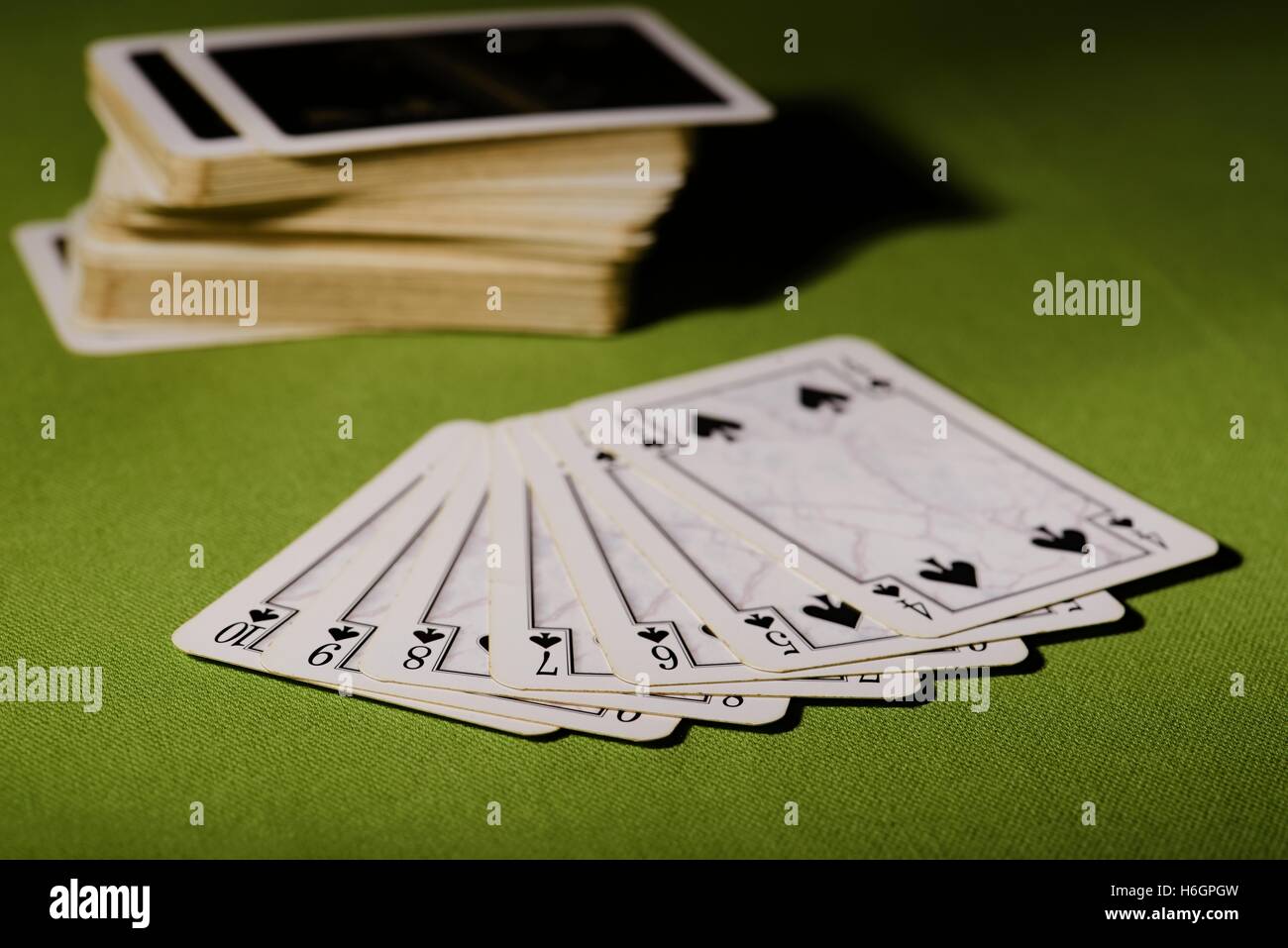 Horizontal photo of used cards placed on green carpet. The cards are ...